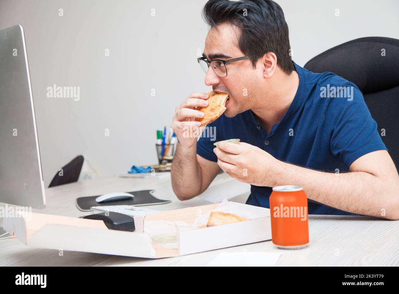Man chilling have food while working and surfing the internet on his ...