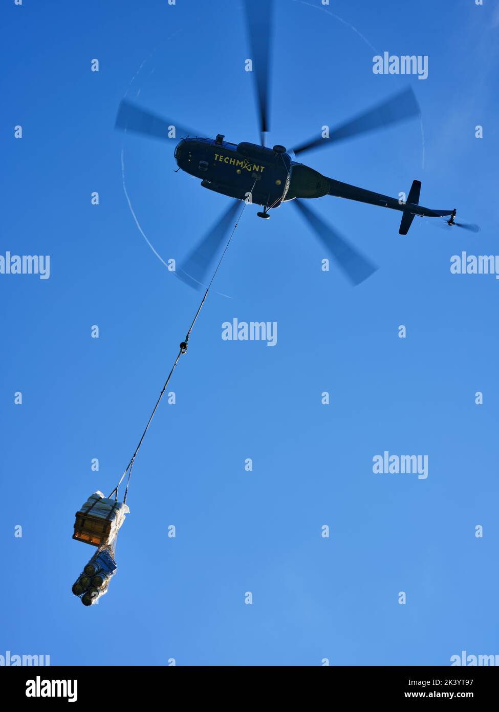 Bottom view of a flying helicopter with cargo suspended on a rope Stock ...