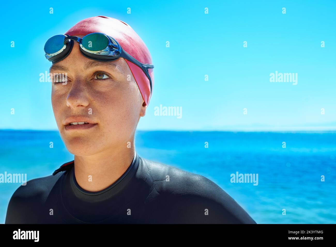 Outdoor exercise. A young swimmer standing and smiling next to the ...