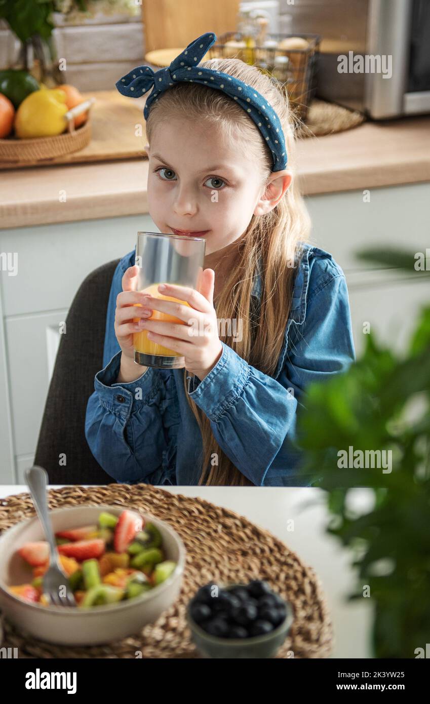 Healthy food at home. Cute little girl eats fruit salad Stock Photo - Alamy