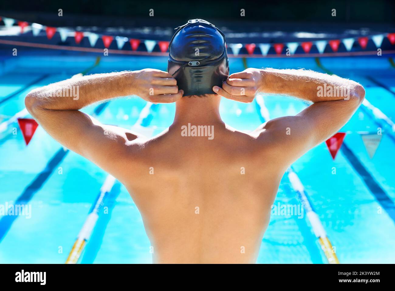 Getting ready to win. Cropped rear view of a male swimmer adjusting his ...