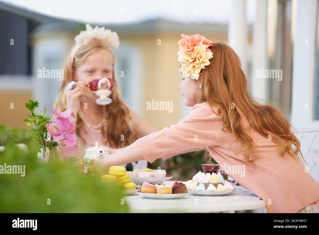 Having a make-believe tea party. Two young girls having a tea party in ...