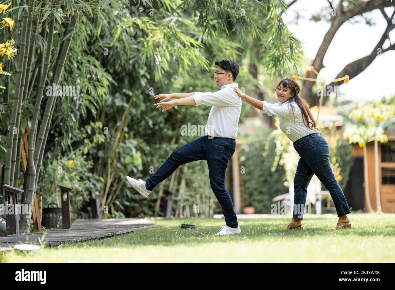 Asian Woman Grabbing and Catching Man shoulder and bracing the man to ...