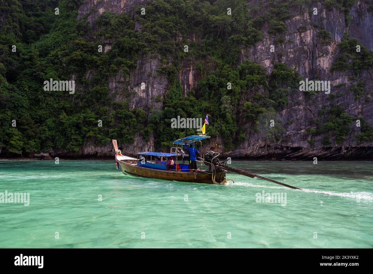 An aerial view of long tail boat floating in sea in background of ...