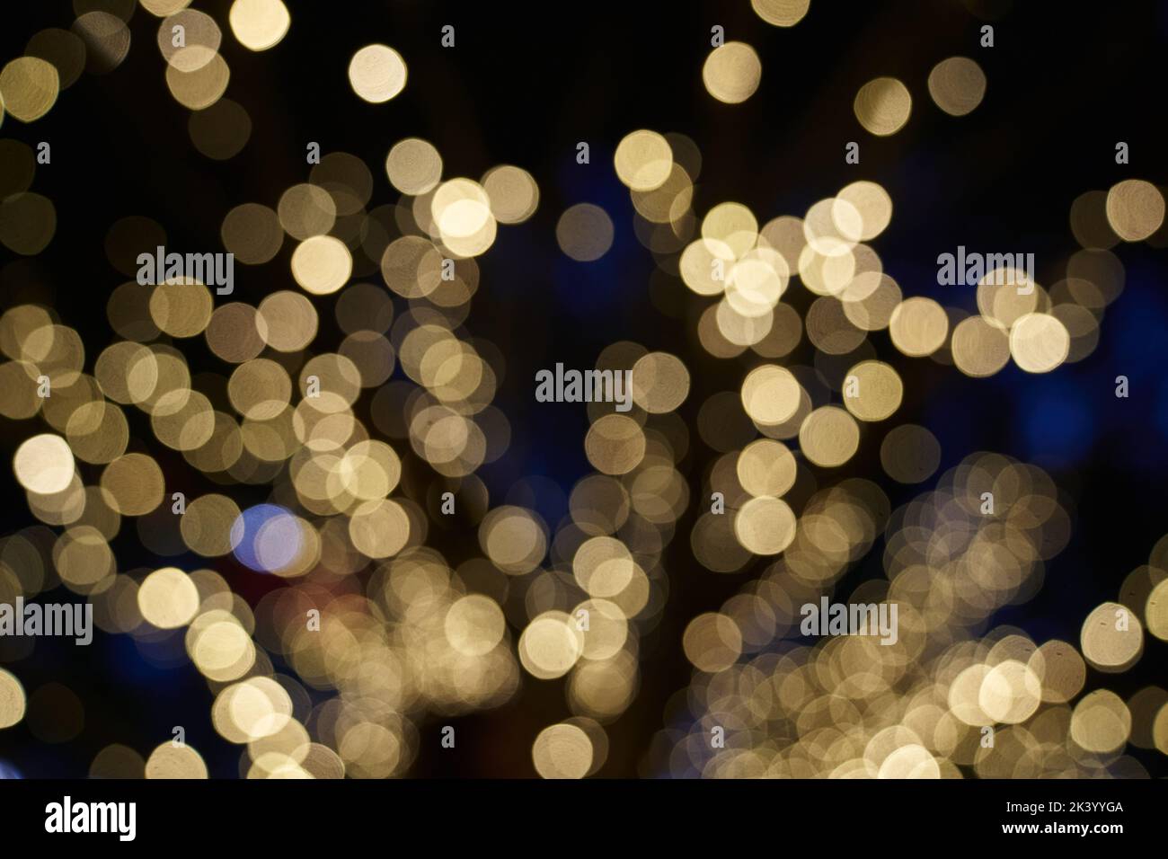 Blurry glowing bokeh lights highlighted on a black background. Festive ...