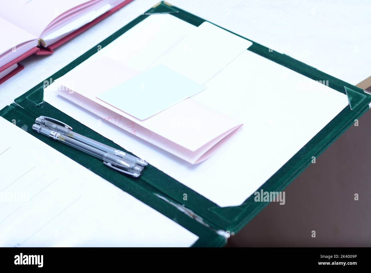 Open documents and pen on a wood desk of a man Stock Photo - Alamy