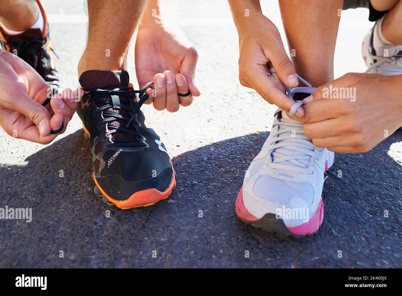 Lacing up before the run. two athletes tying their shoelaces Stock ...