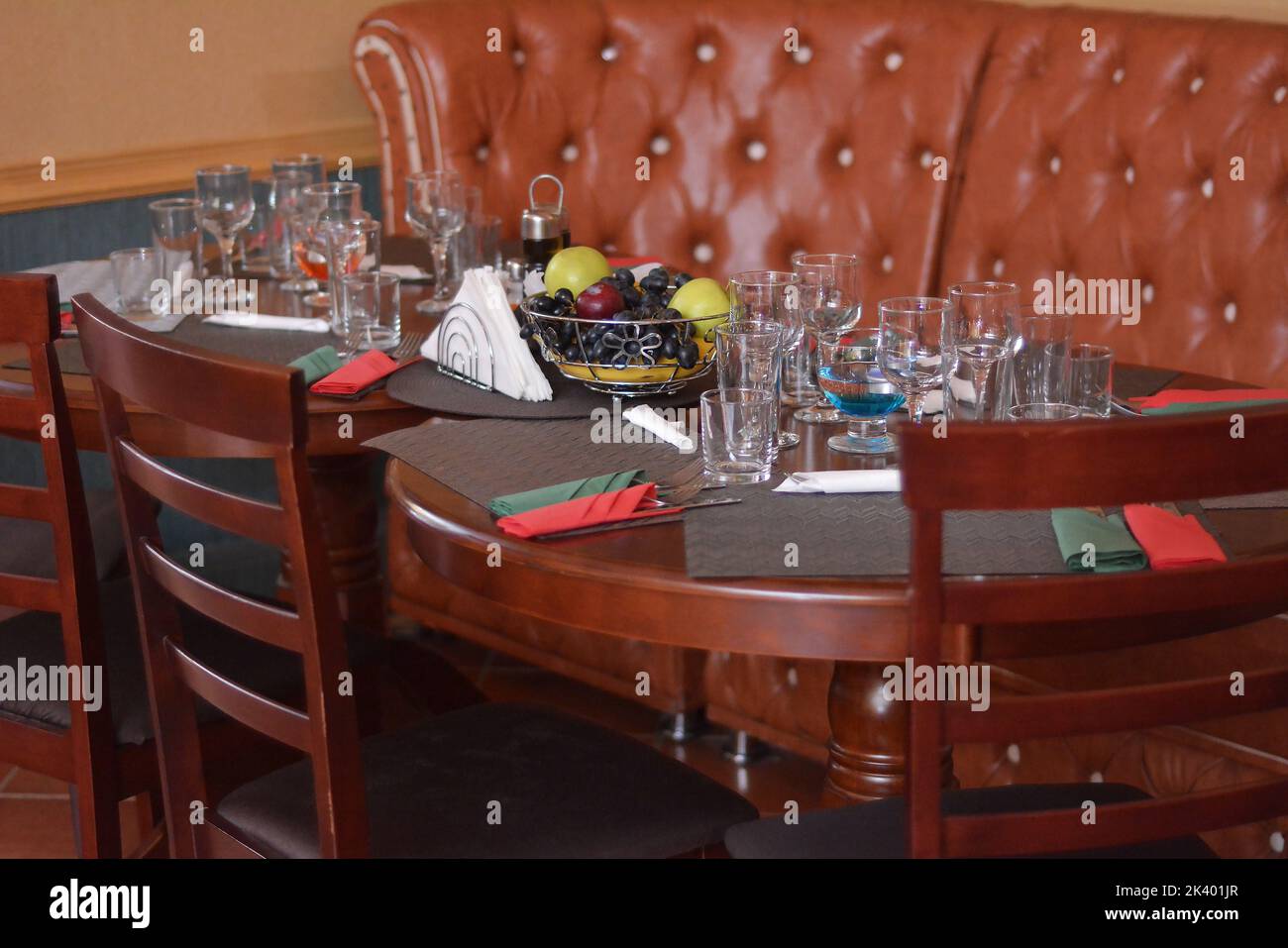 Wooden chairs and tables with a leader sofa Stock Photo - Alamy