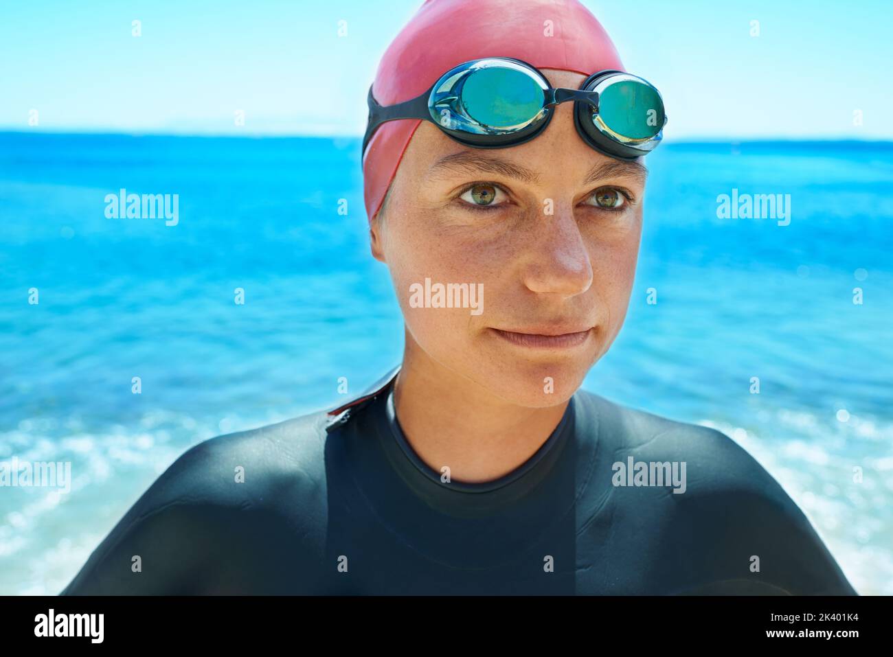 Outdoor exercise. A young swimmer standing and smiling next to the ...