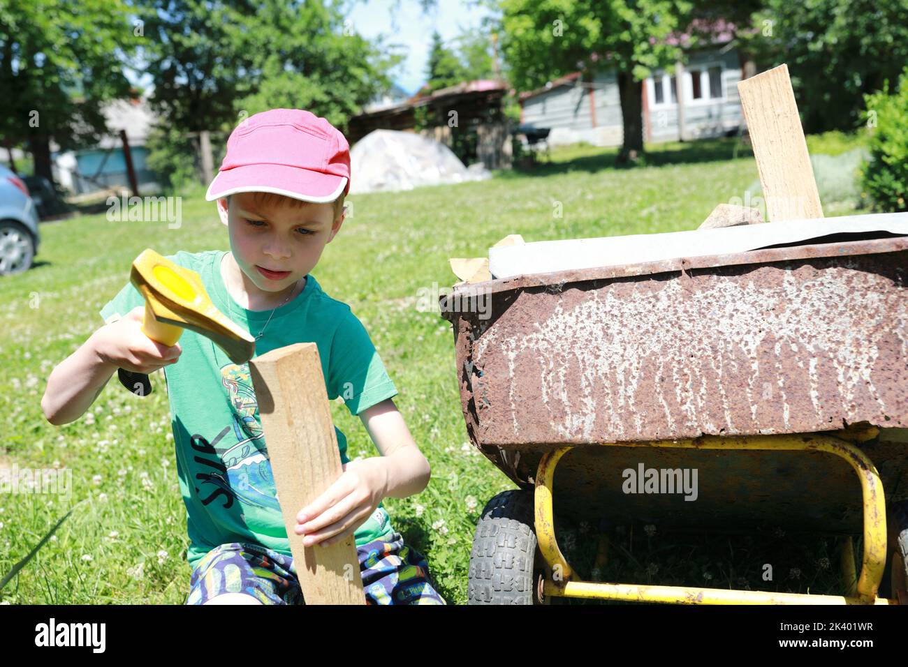 Boy chopping wood with ax in backyard Stock Photo - Alamy