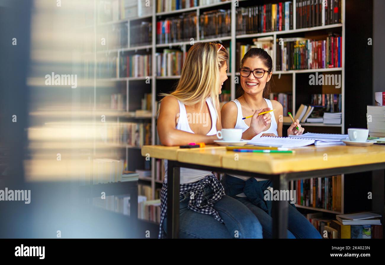 Group of happy young female studying together in college library. Study ...