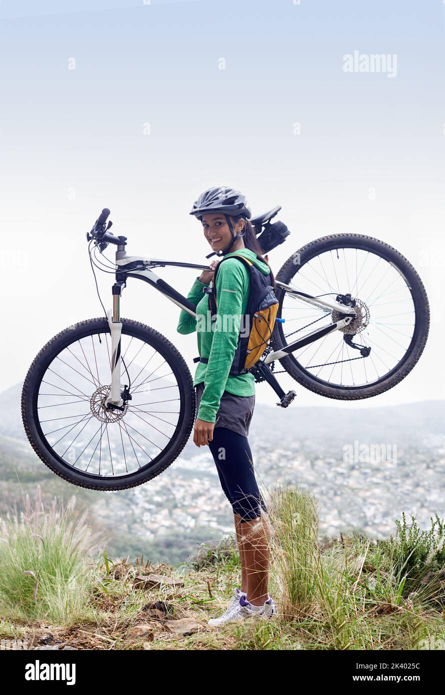 Exploring the mountains with my bicycle. A pretty young woman carrying ...