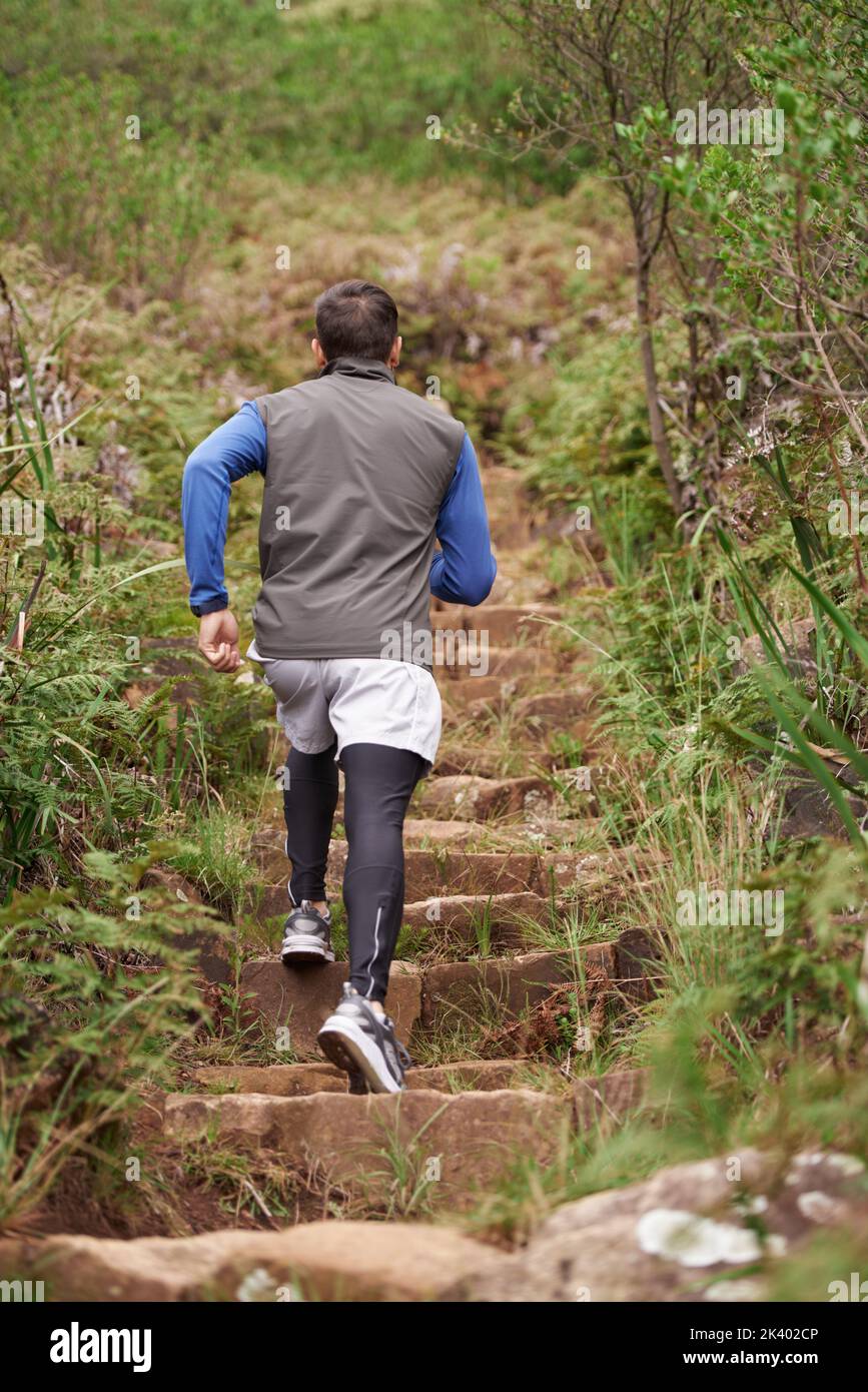 Getting his heart-rate pumping. A young man running up a mountain path ...
