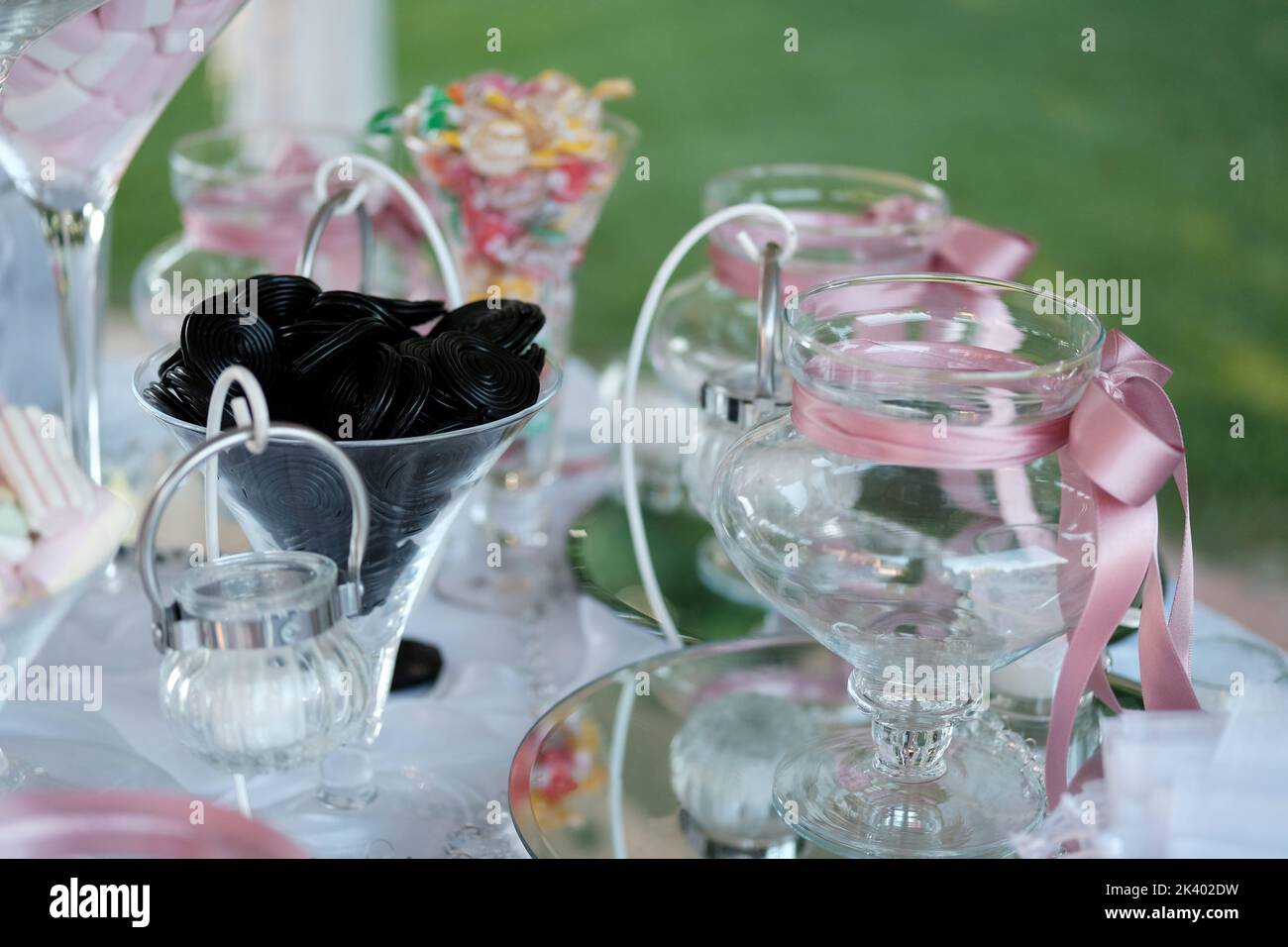 Italian candy bar with licorice snails and many glasses with pink ...