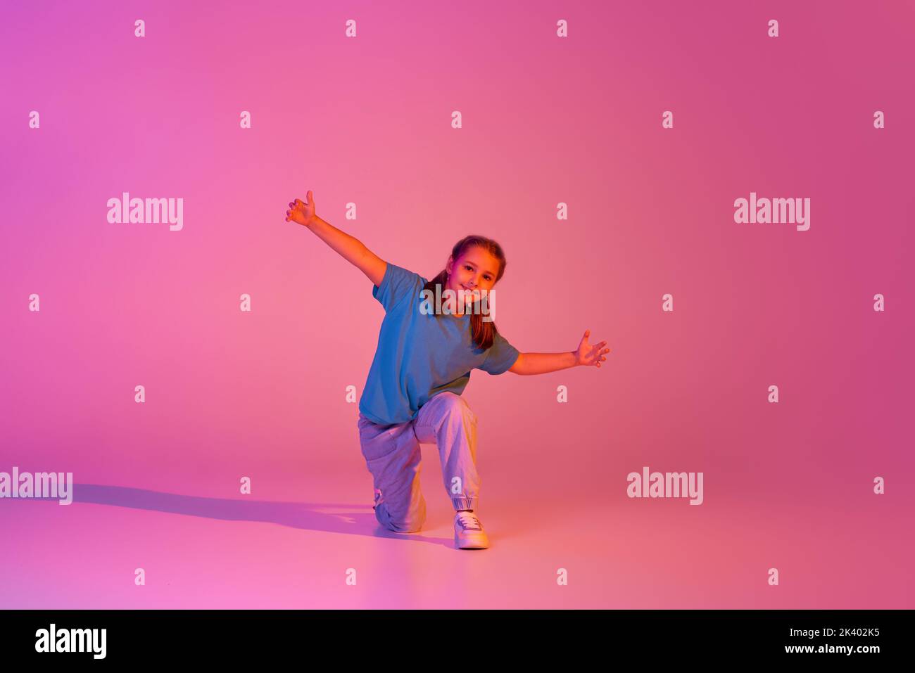 Portrait of caucasian little girl, kid in casual bright clothes dancing ...