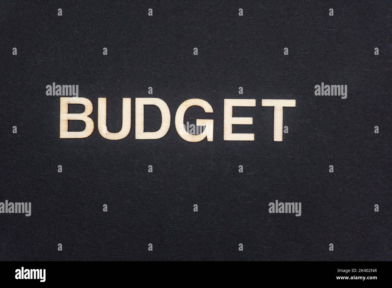 BUDGET word written on dark paper background. BUDGET text on dark for ...