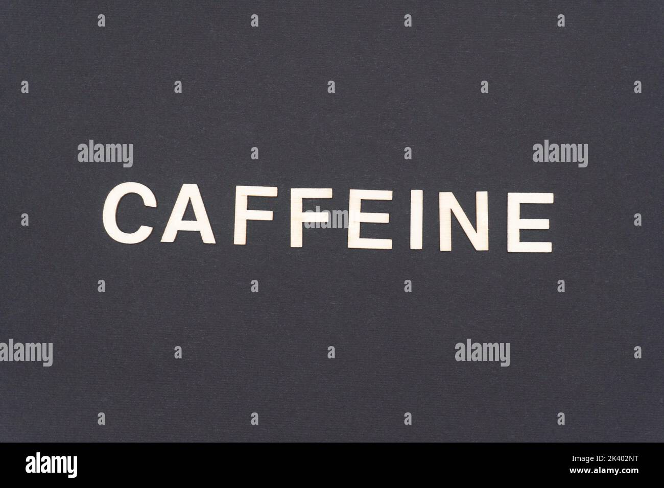 CAFFEINE word written on dark paper background. CAFFEINE text on dark ...
