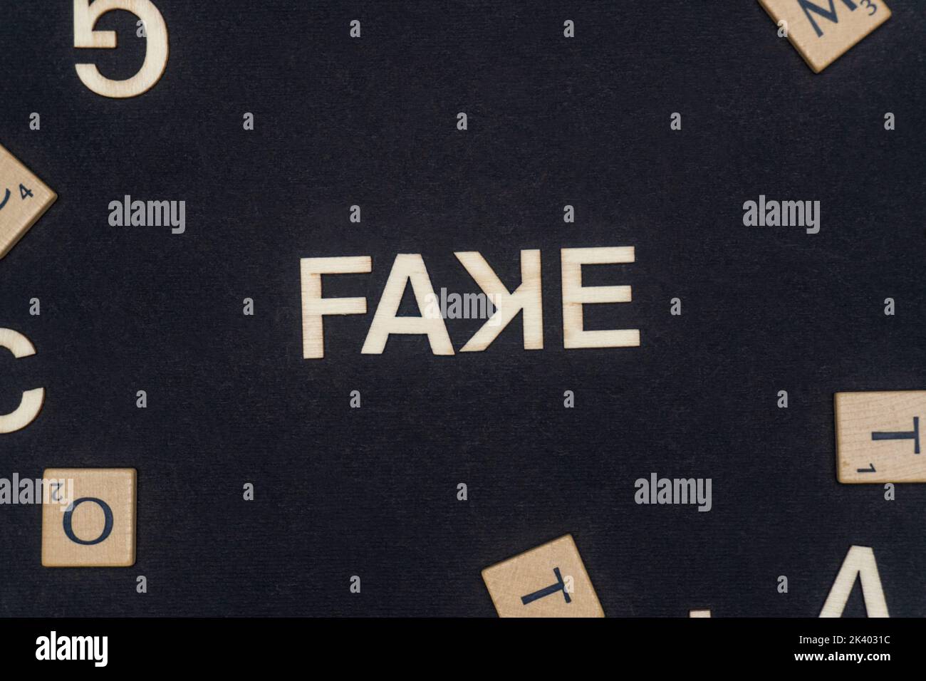 FAKE word written on dark paper background. FAKE text on dark for your ...