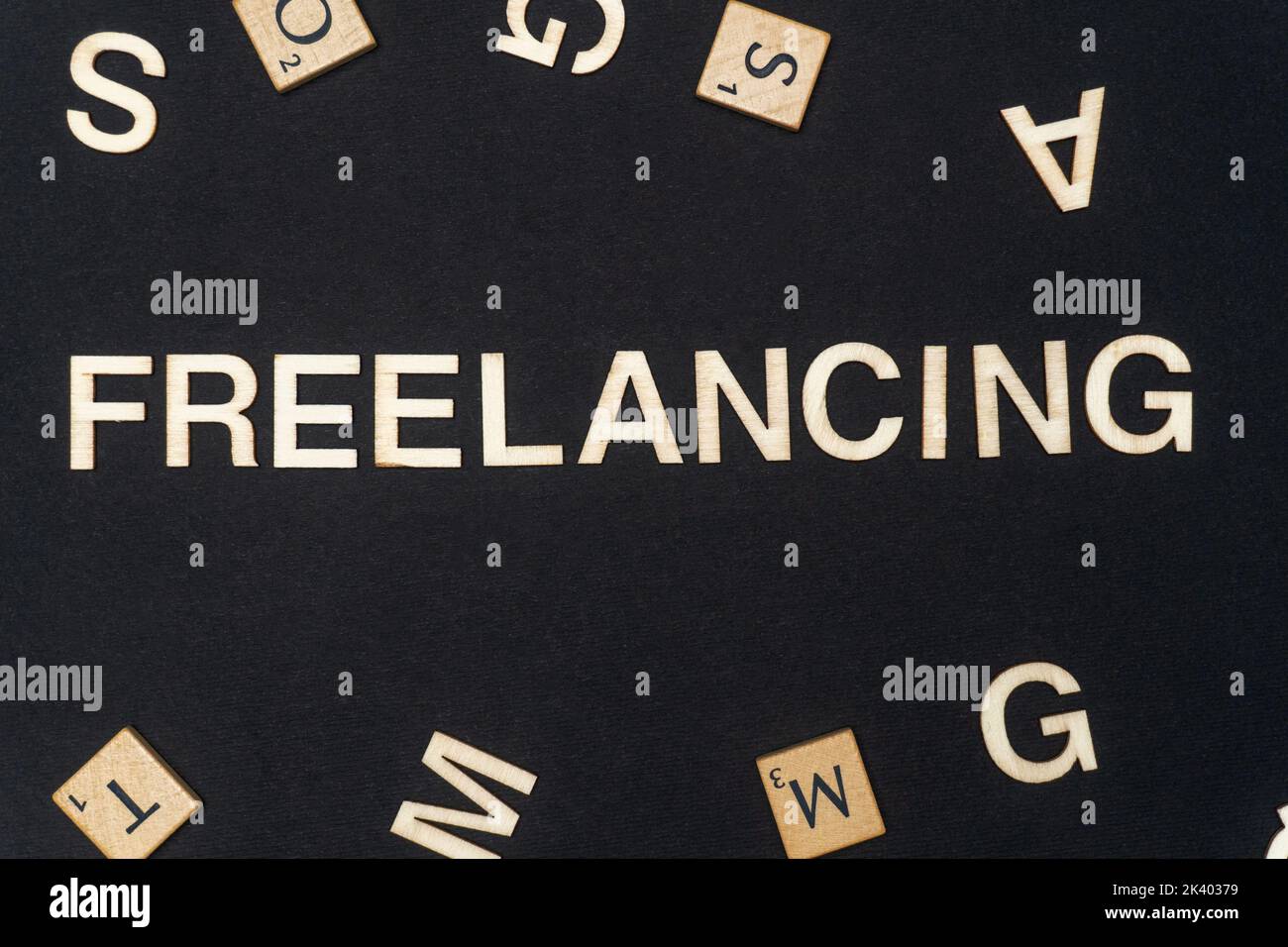 FREELANCING word written on dark paper background. FREELANCING text on ...