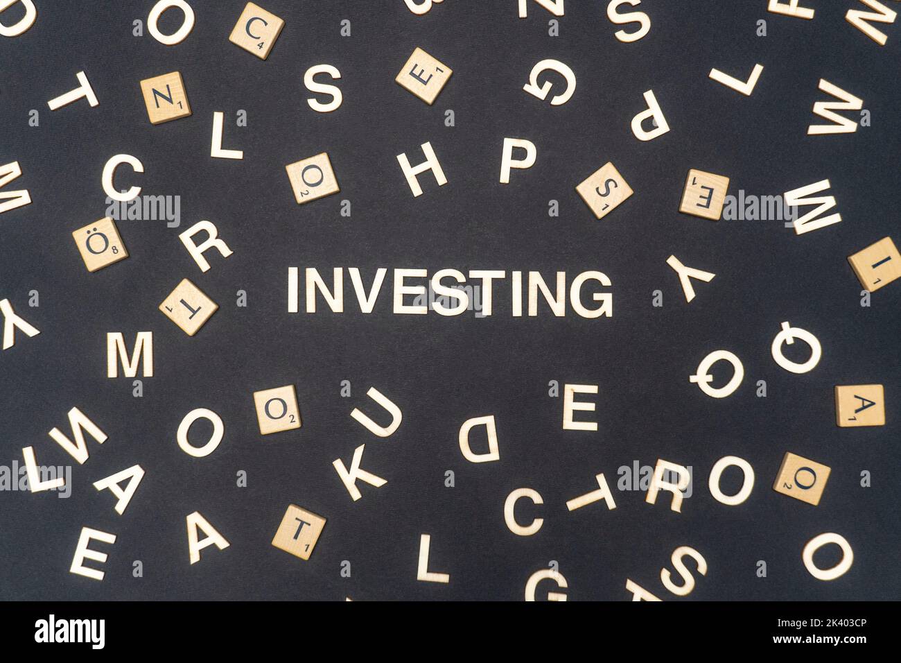 INVESTING word written on dark paper background. INVESTING text on dark ...