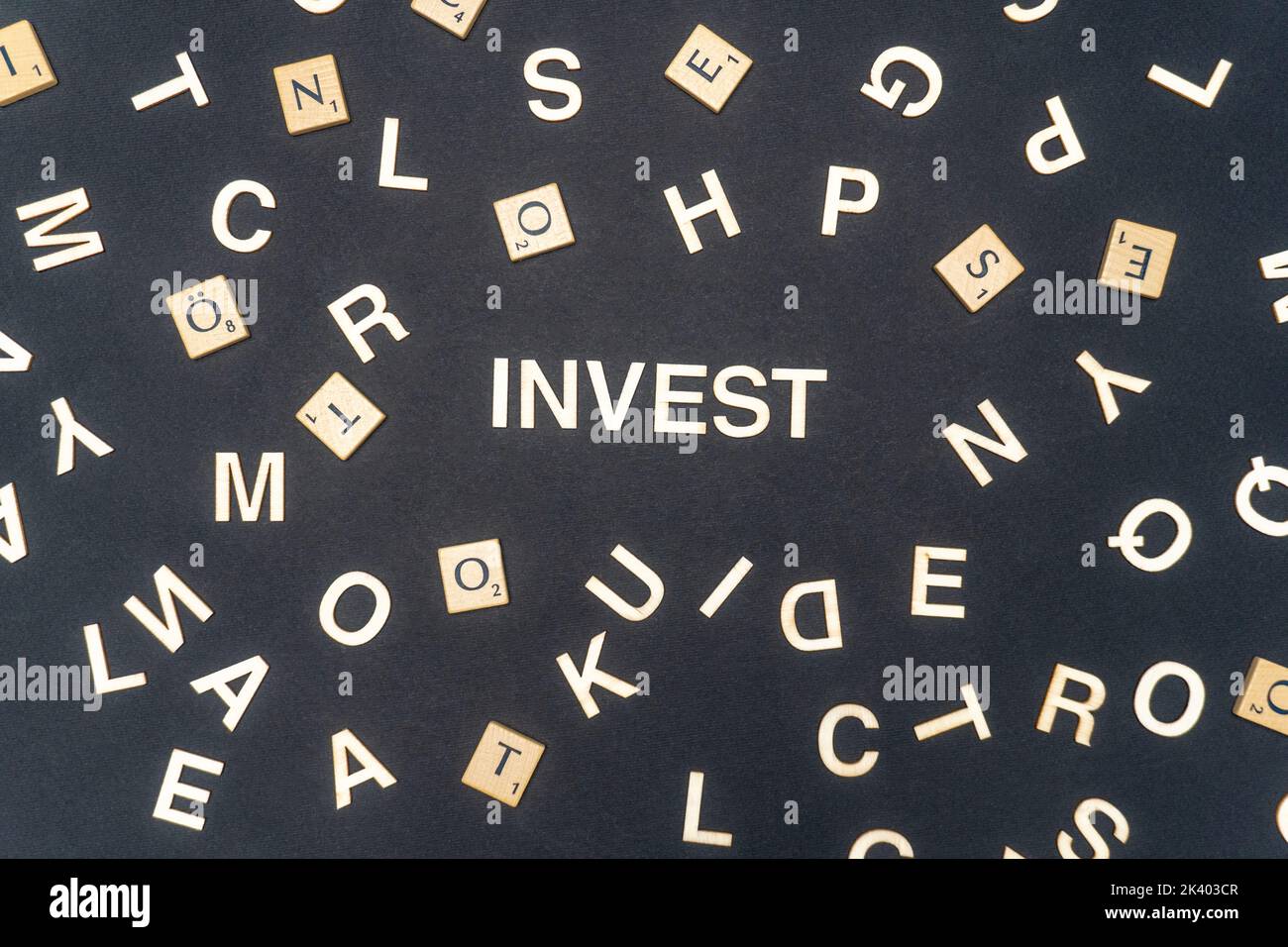 INVEST word written on dark paper background. INVEST text on dark for ...