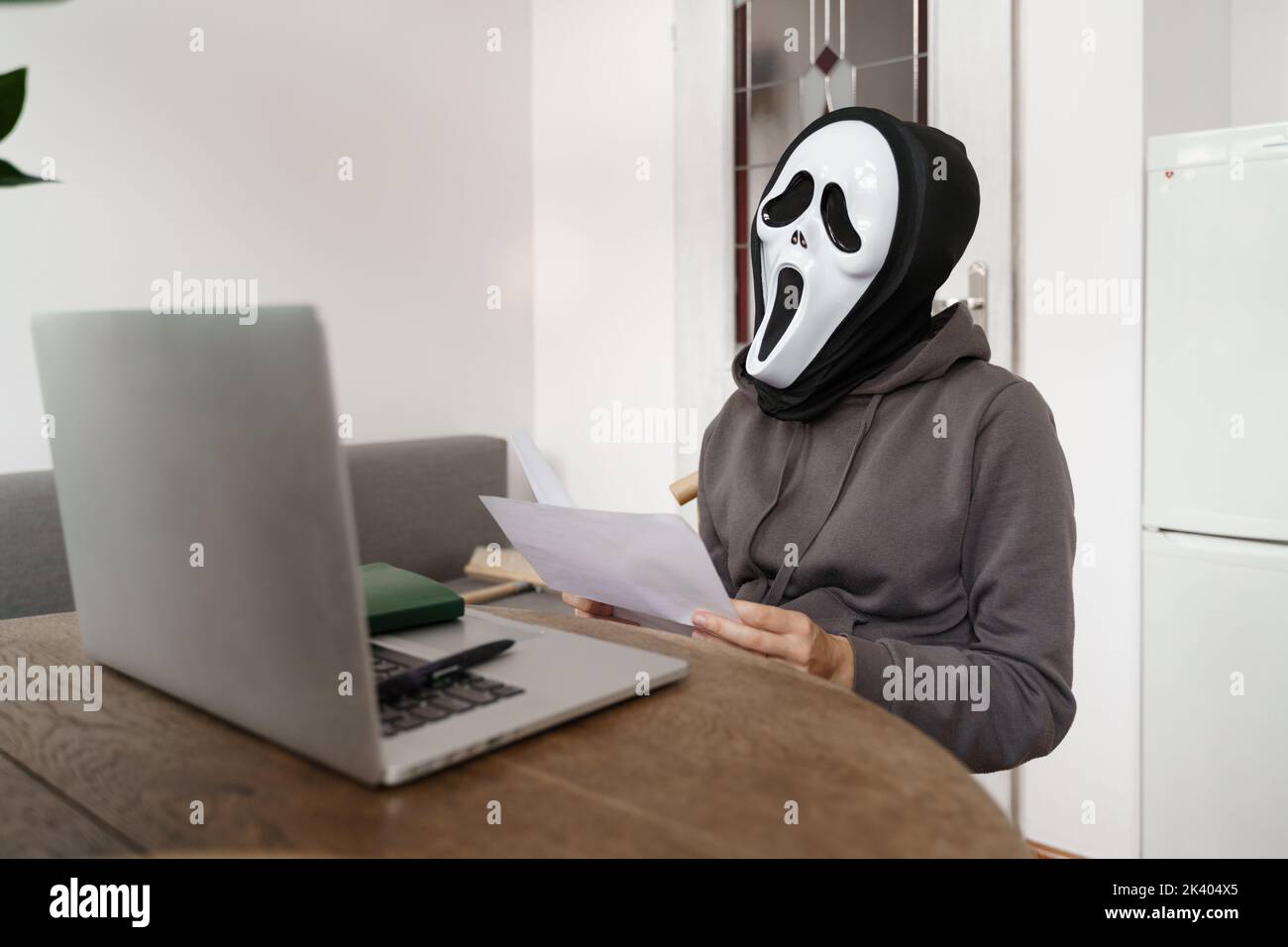 Anonymous person with ghost mask checking papers. Energy crisis and ...