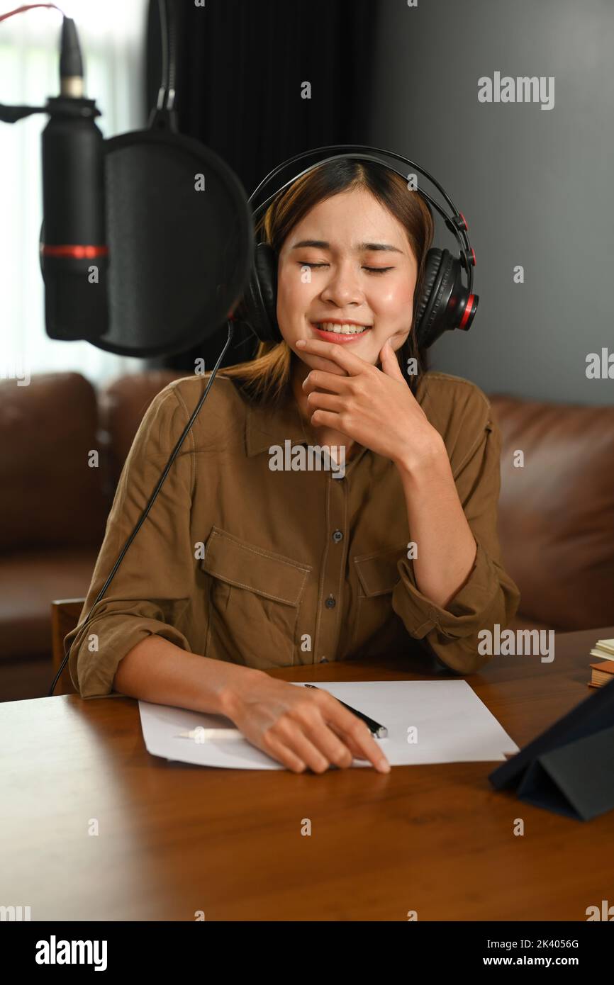 Charming female radio host listening to interesting conversation with ...