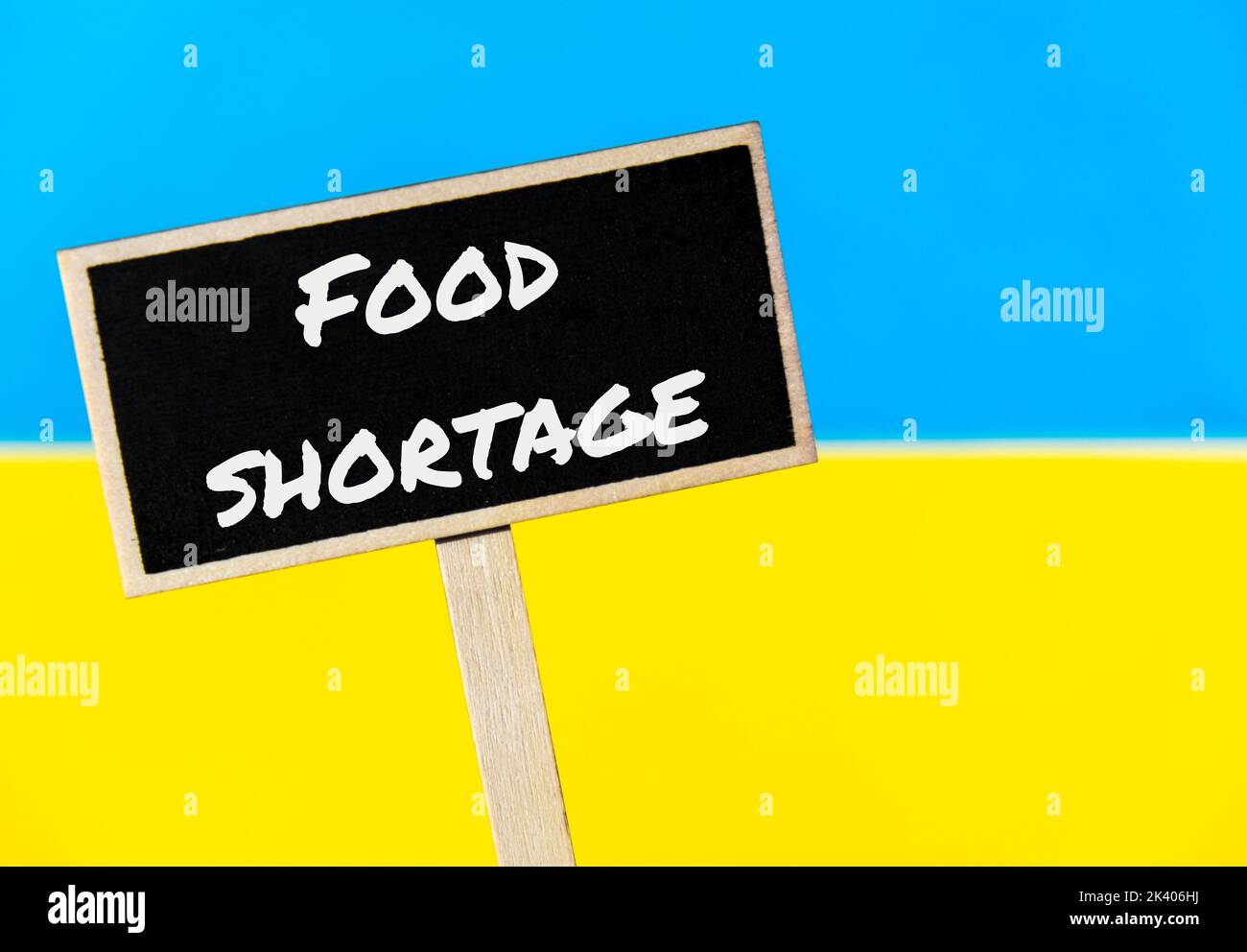 Wooden information label sign with text FOOD SHORTAGE against Ukrainian ...