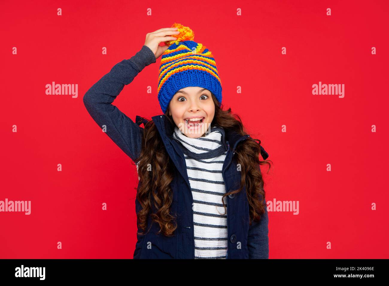 express positive emotion. winter fashion. surprised kid with curly hair ...