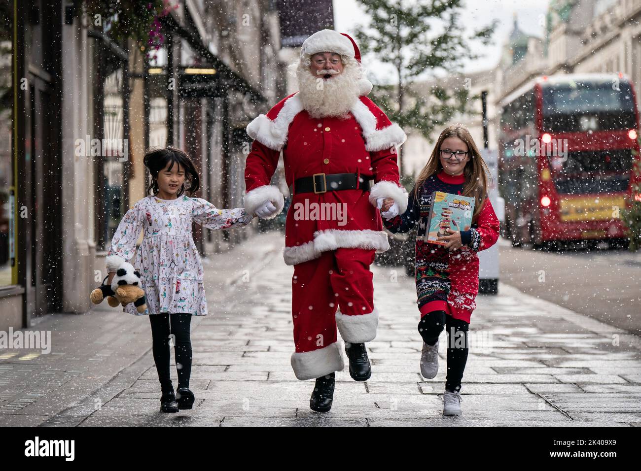 Mai Leung, 6, (right) and Leia Carter, 10, skips with a man dressed as ...