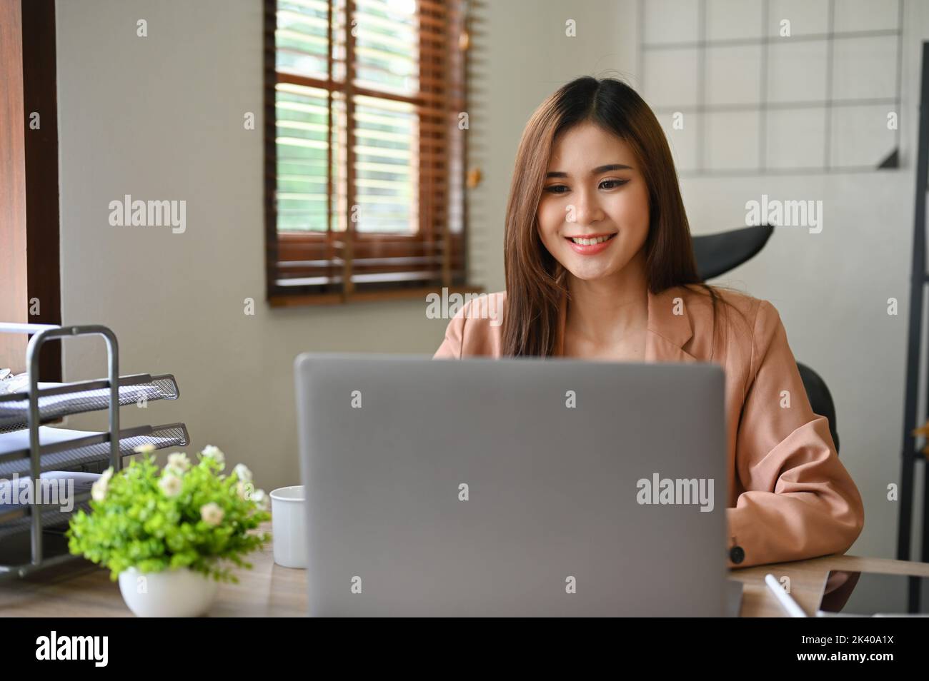 Pretty and charming young Asian businesswoman or female manager working ...