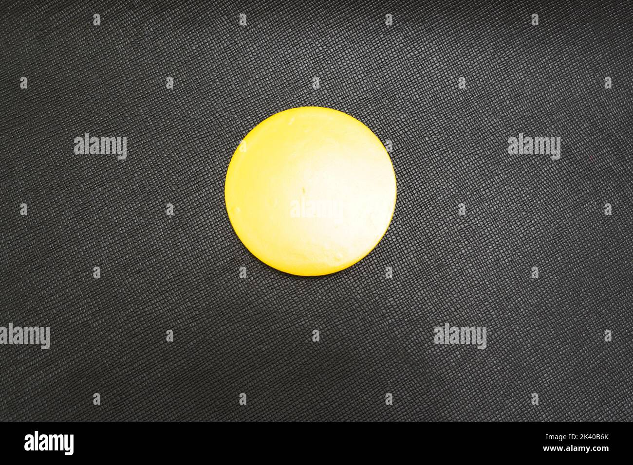 toy rings with yellow wooden flowers over textured black background ...