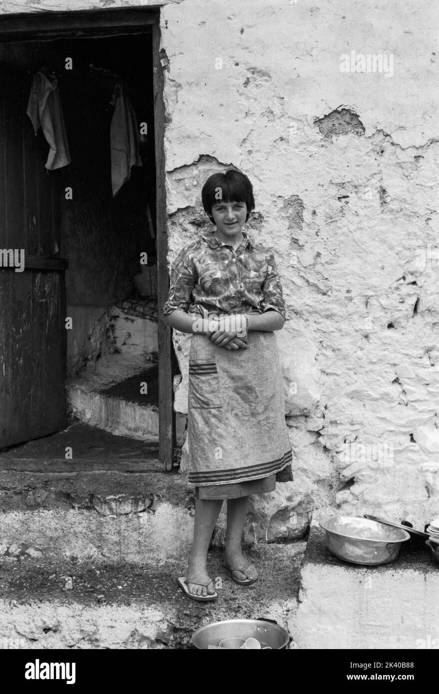 Girl outside rural farmhouse with cooking pots, Crete, Greece ...