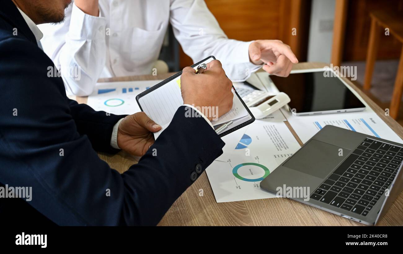 Professional Asian male boss or businessman noting something on a paper ...