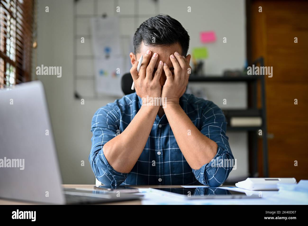 Stressed and exhausted Asian businessman or male office worker sits at ...