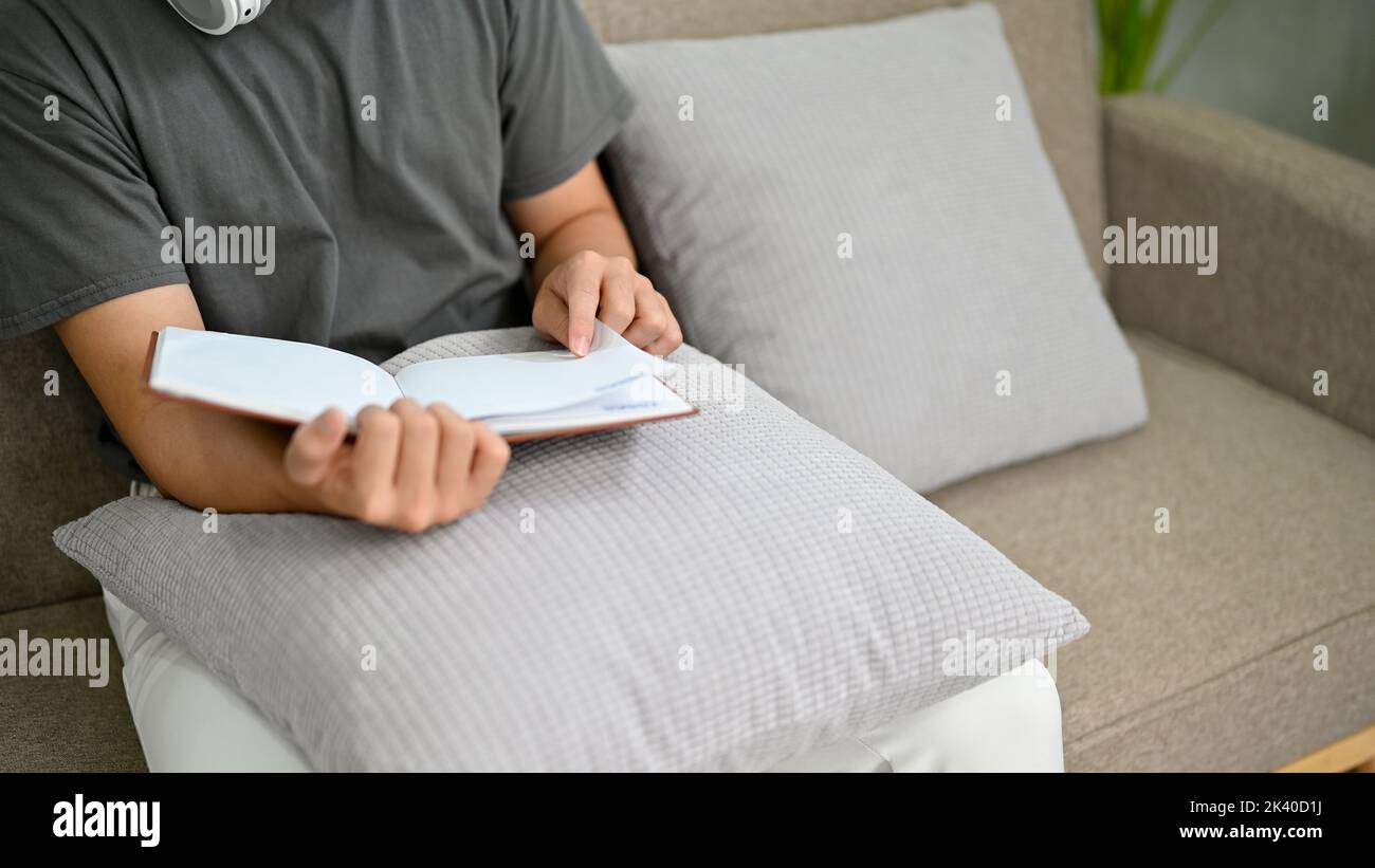 A smart young Asian man reading a book or textbook while relaxing on a ...