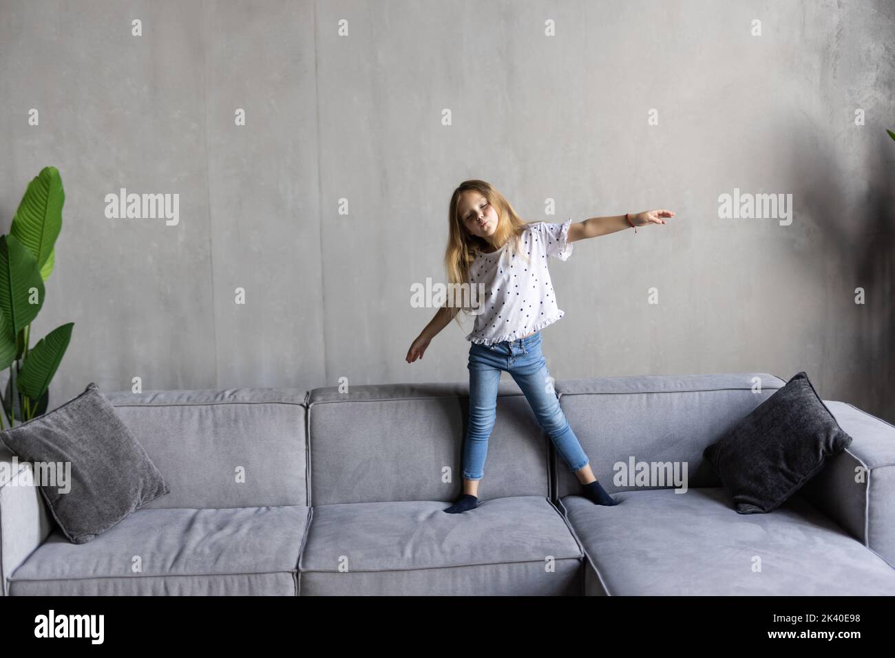 Adorable little girl jumping at home on sofa Stock Photo - Alamy