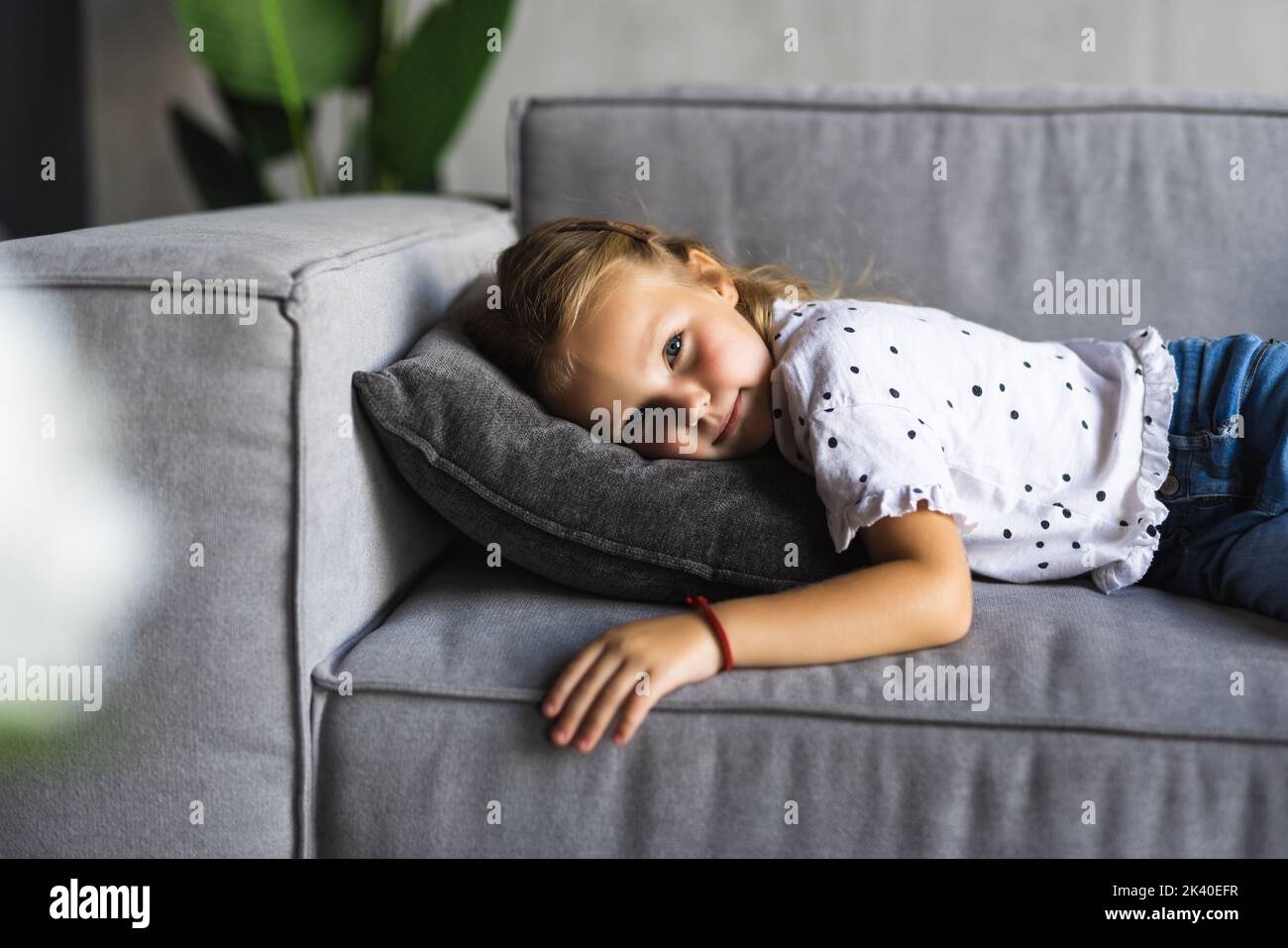 Close up little girl taking day nap, sleeping on cozy comfortable couch ...
