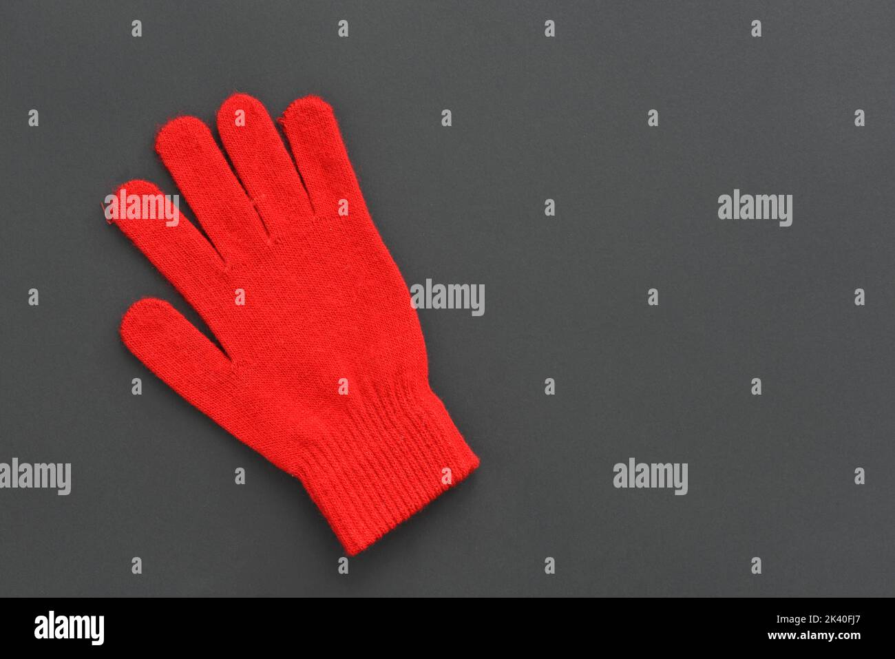 Warm woolen knitted glove on dark texture Stock Photo - Alamy