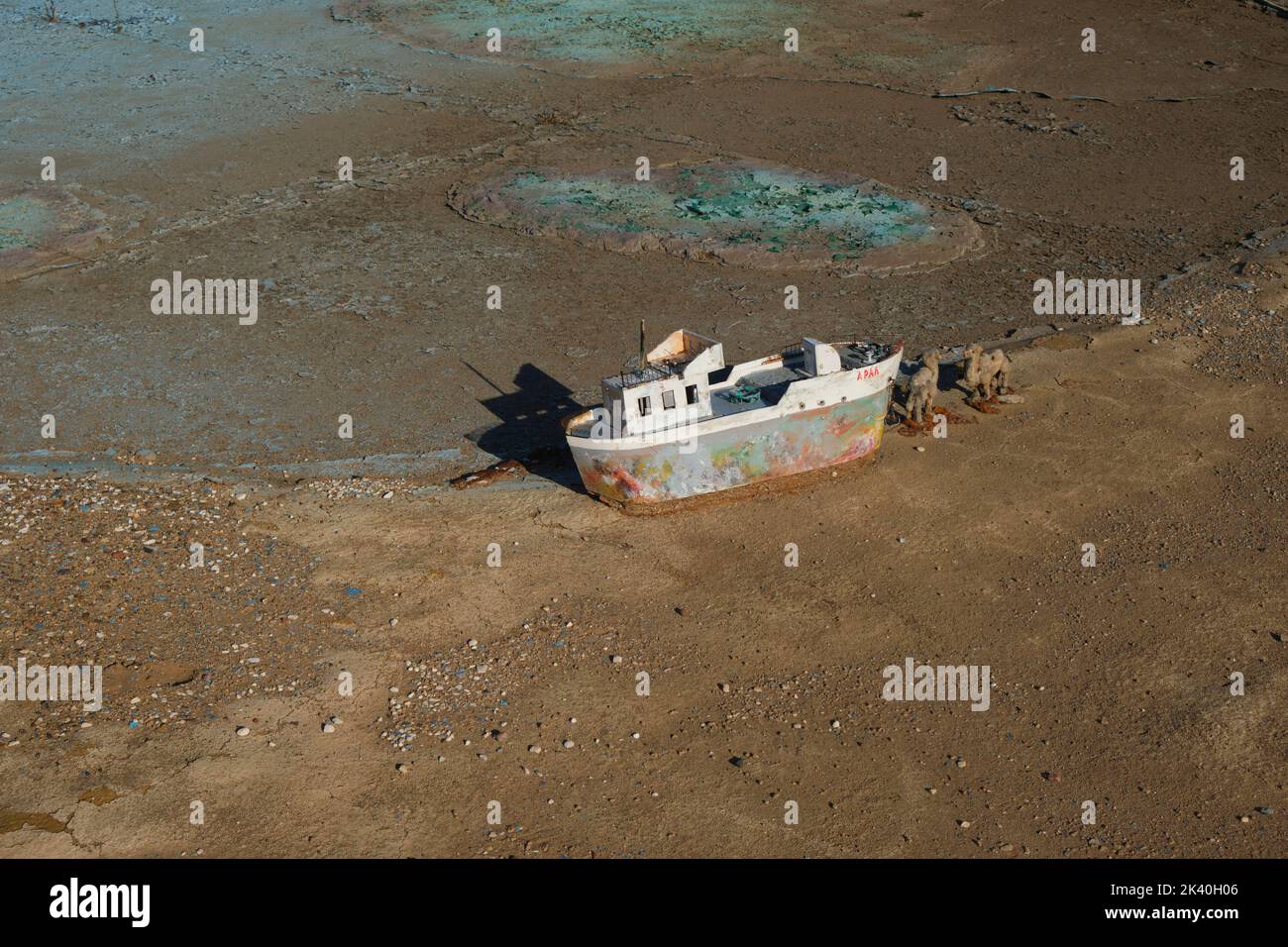 A sad model of a stranded old fishing boat and a couple of camels at ...