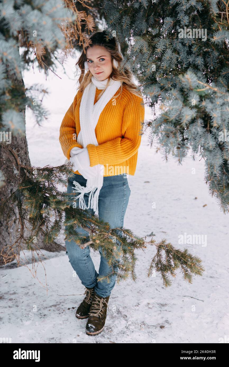 Teen blonde in a yellow sweater outside in winter. A teenage girl on a ...