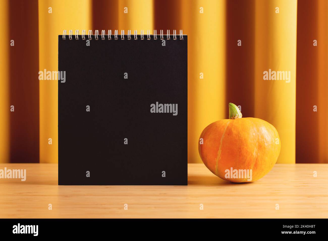 Autumn composition with blank black page and orange pumpkin against ...