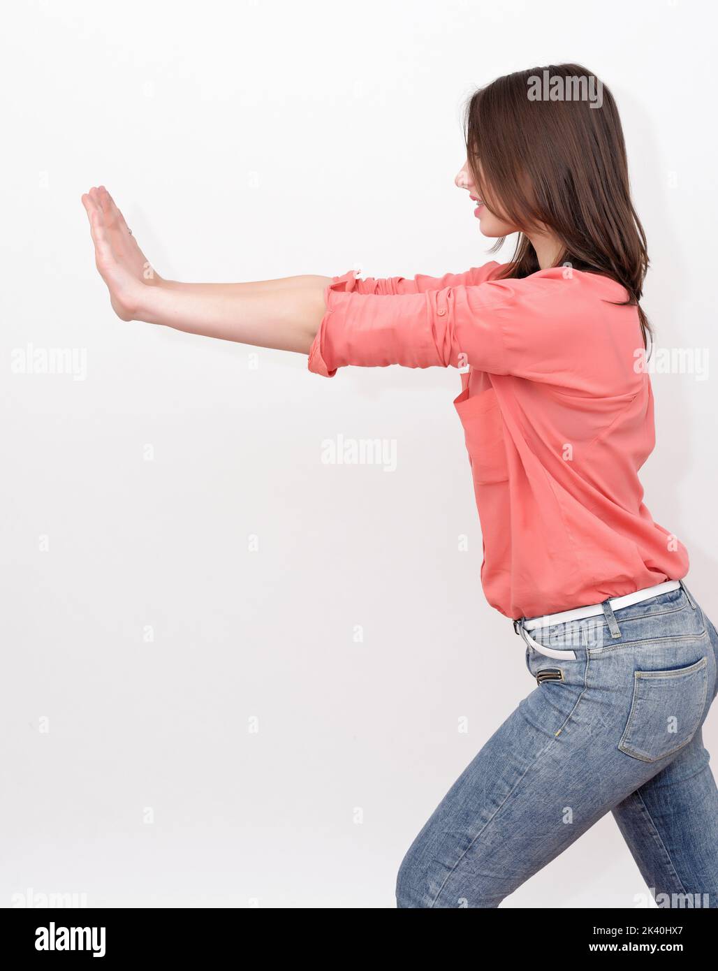 Woman pushing something imaginary - isolated over a white background ...