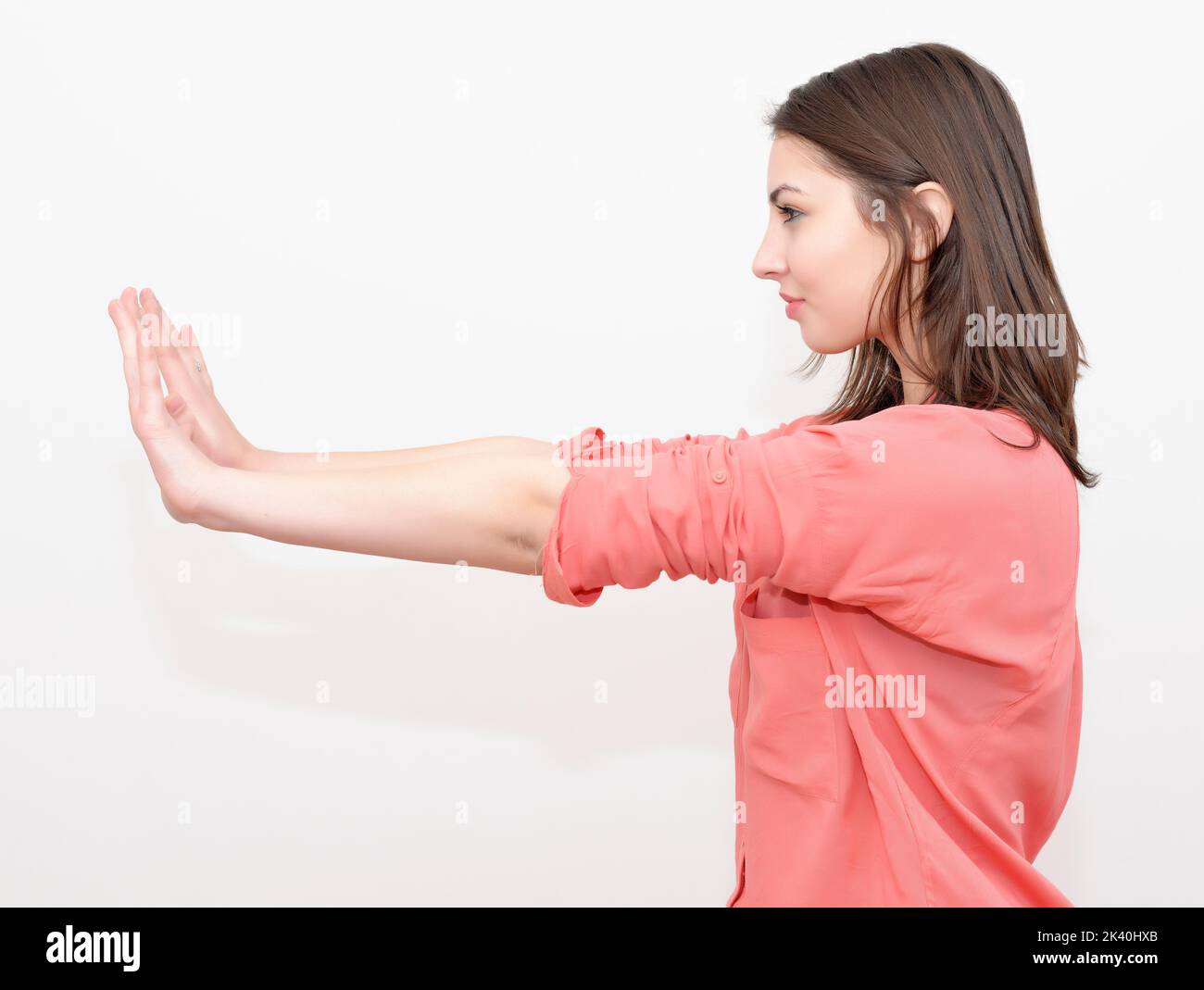 Woman pushing something imaginary - isolated over a white background ...