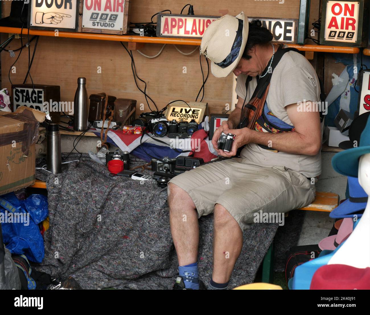 Stall holder fixing a camera before adding to his shelves to sell Stock ...