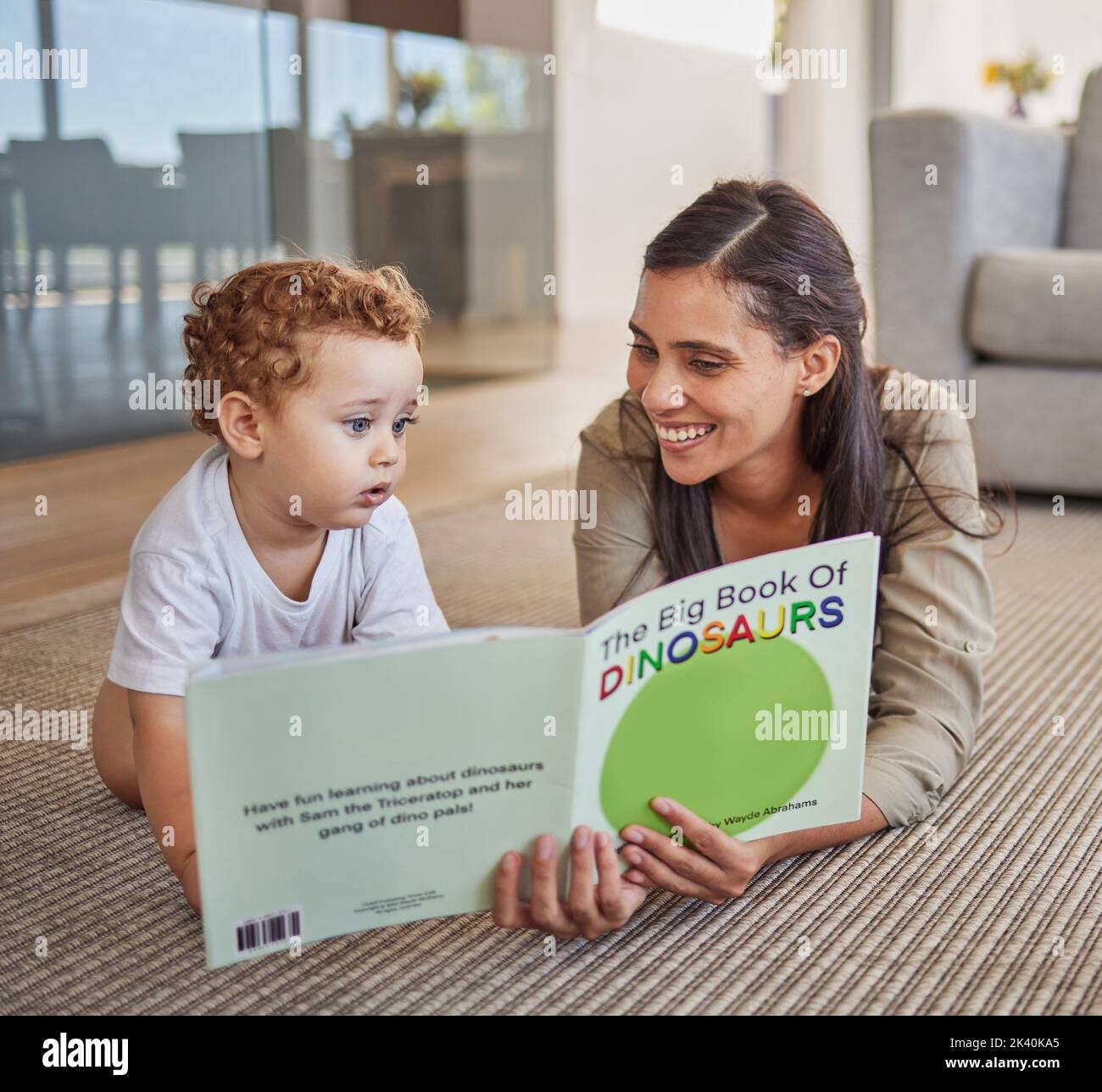 Mom, child and reading dinosaur books on living room floor at family ...