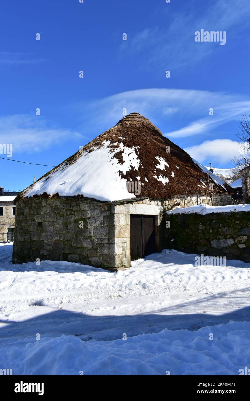 Ancient snowy palloza round house made with stone and straw. Piornedo ...