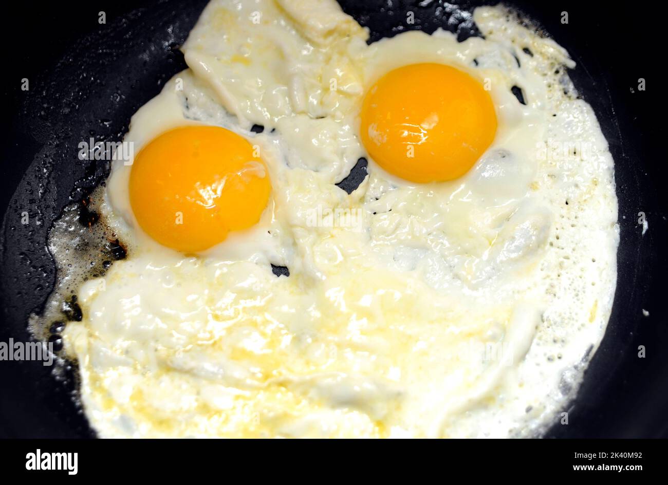 Close-up photo of two scrambled eggs in black frying pan stock photo ...