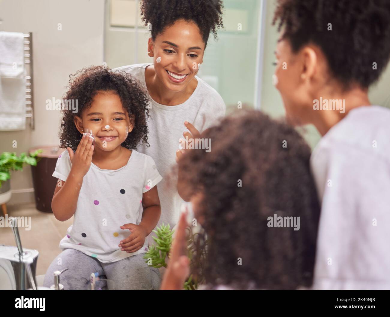 Happy, mother and child with skincare cream in morning routine together ...
