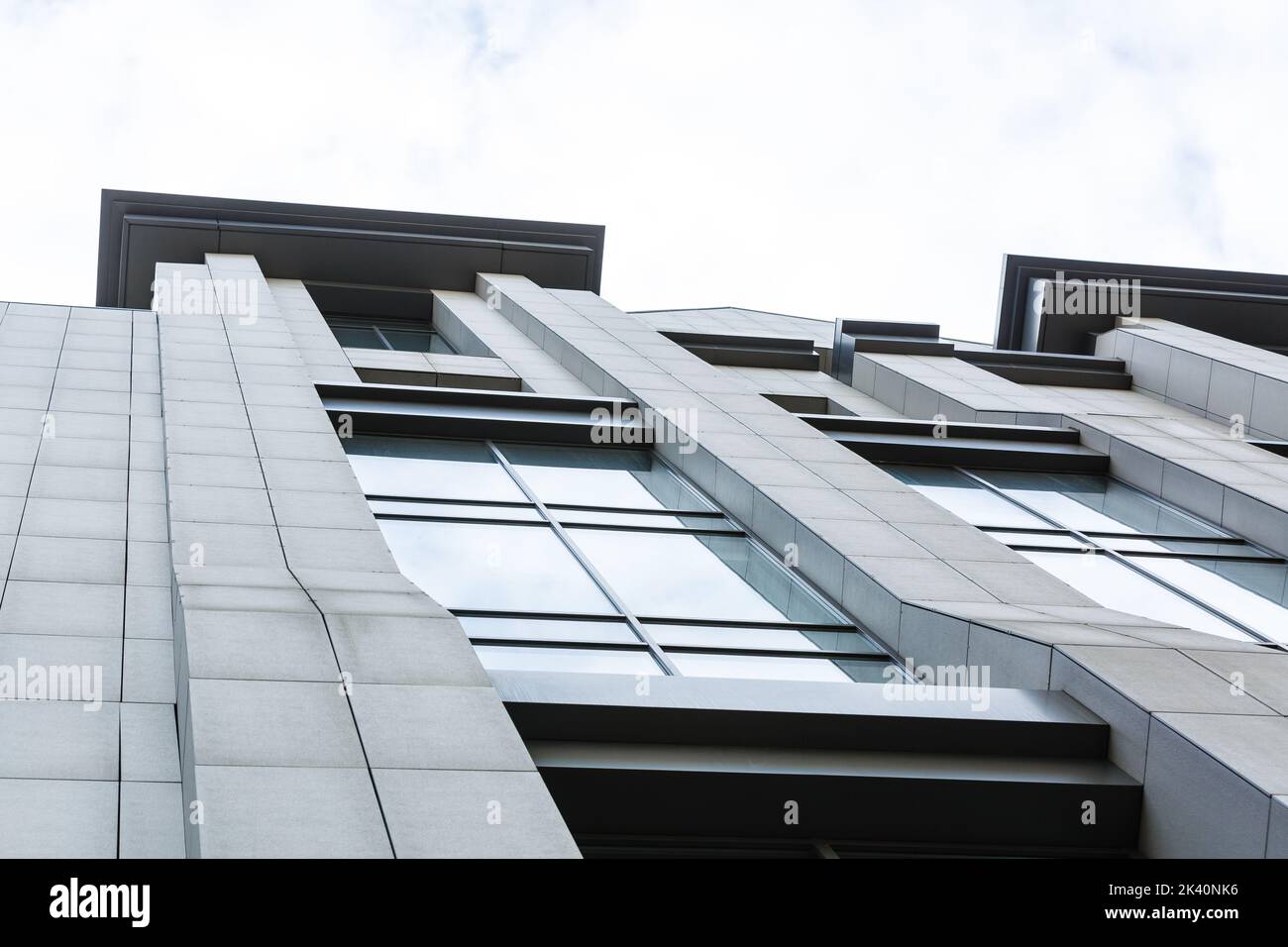 building with windows and grey walls. Windows are reflecting light ...